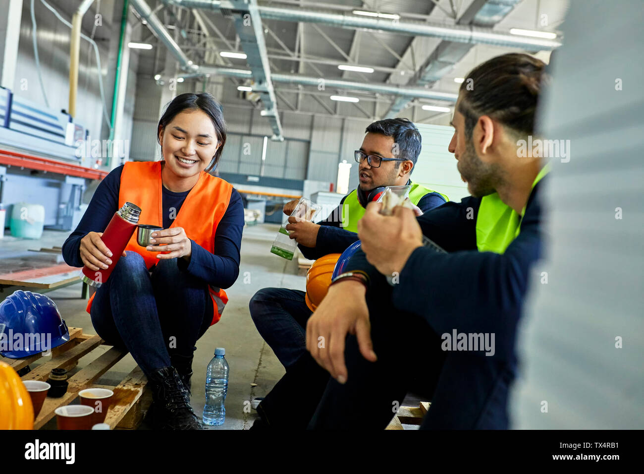 Workers in factory having lunch break together Stock Photo - Alamy