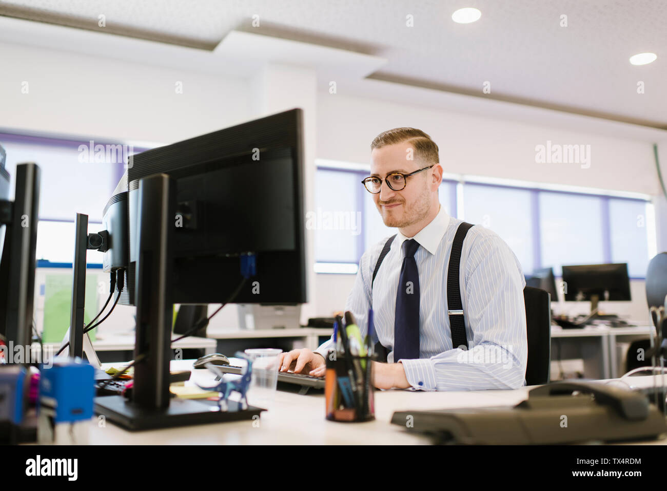 Businessman using computer at desk in office Stock Photo - Alamy