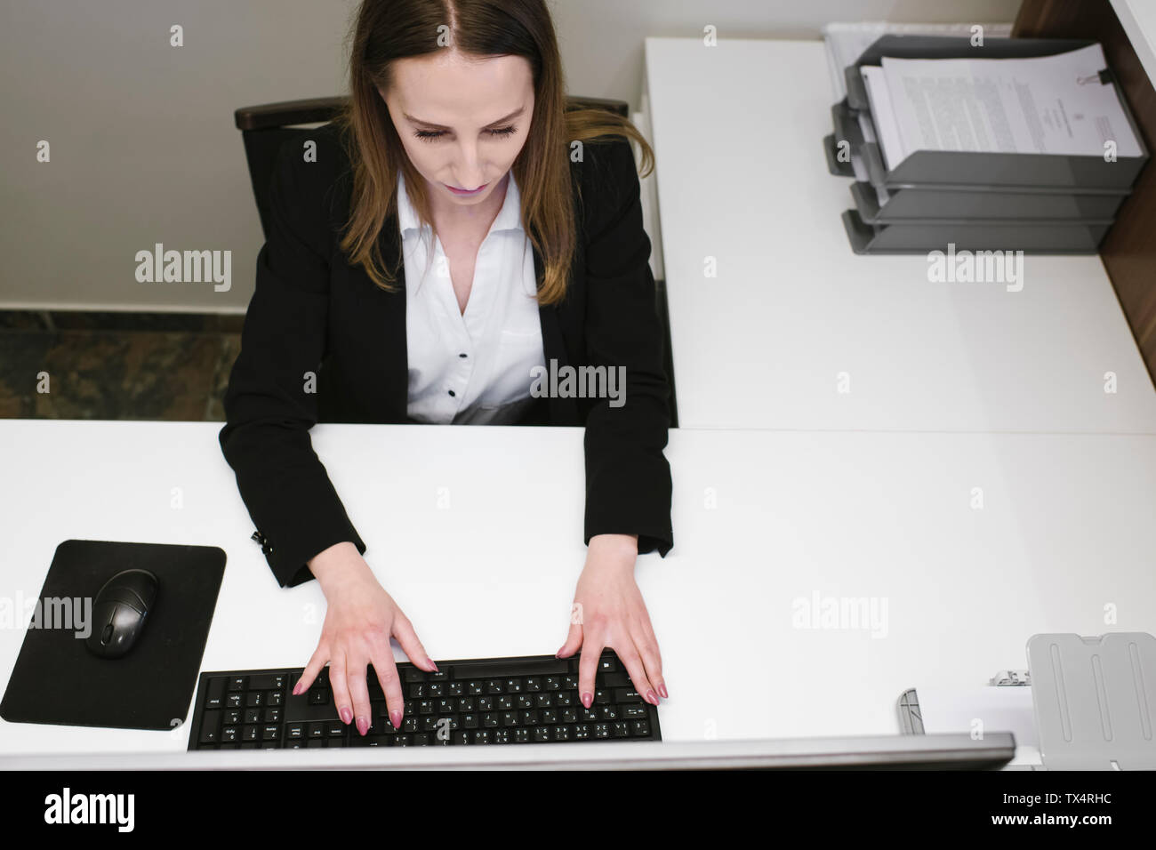 Young woman working at the reception desk in office Stock Photo - Alamy
