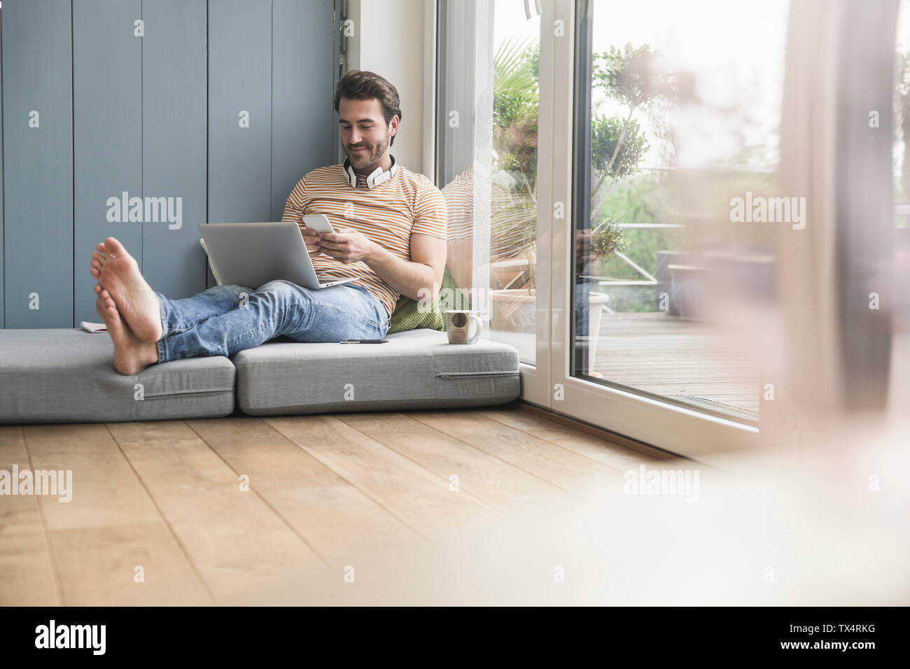 Using smartphone with headphones around neck hi-res stock photography ...