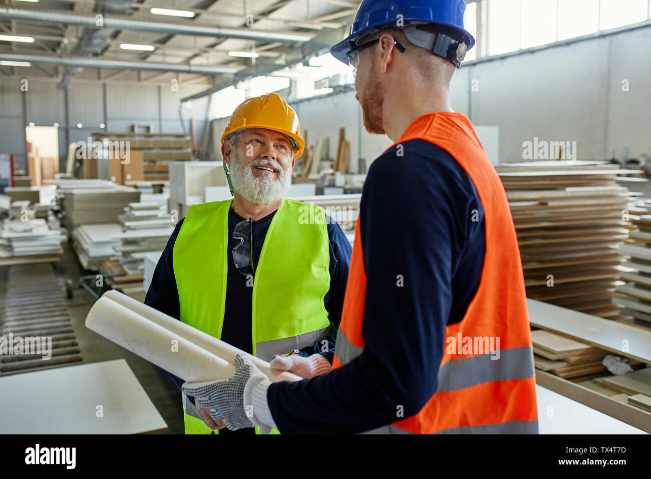 Two men with plan talking in factory Stock Photo - Alamy