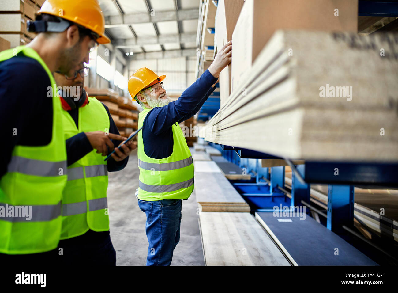 Workers talking in factory warehouse Stock Photo - Alamy