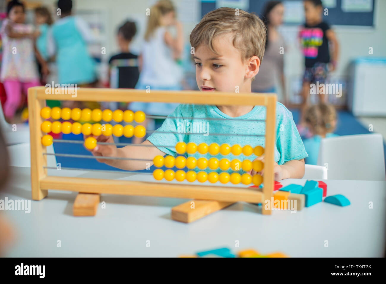 Boy in kindergarten using abacus Stock Photo - Alamy