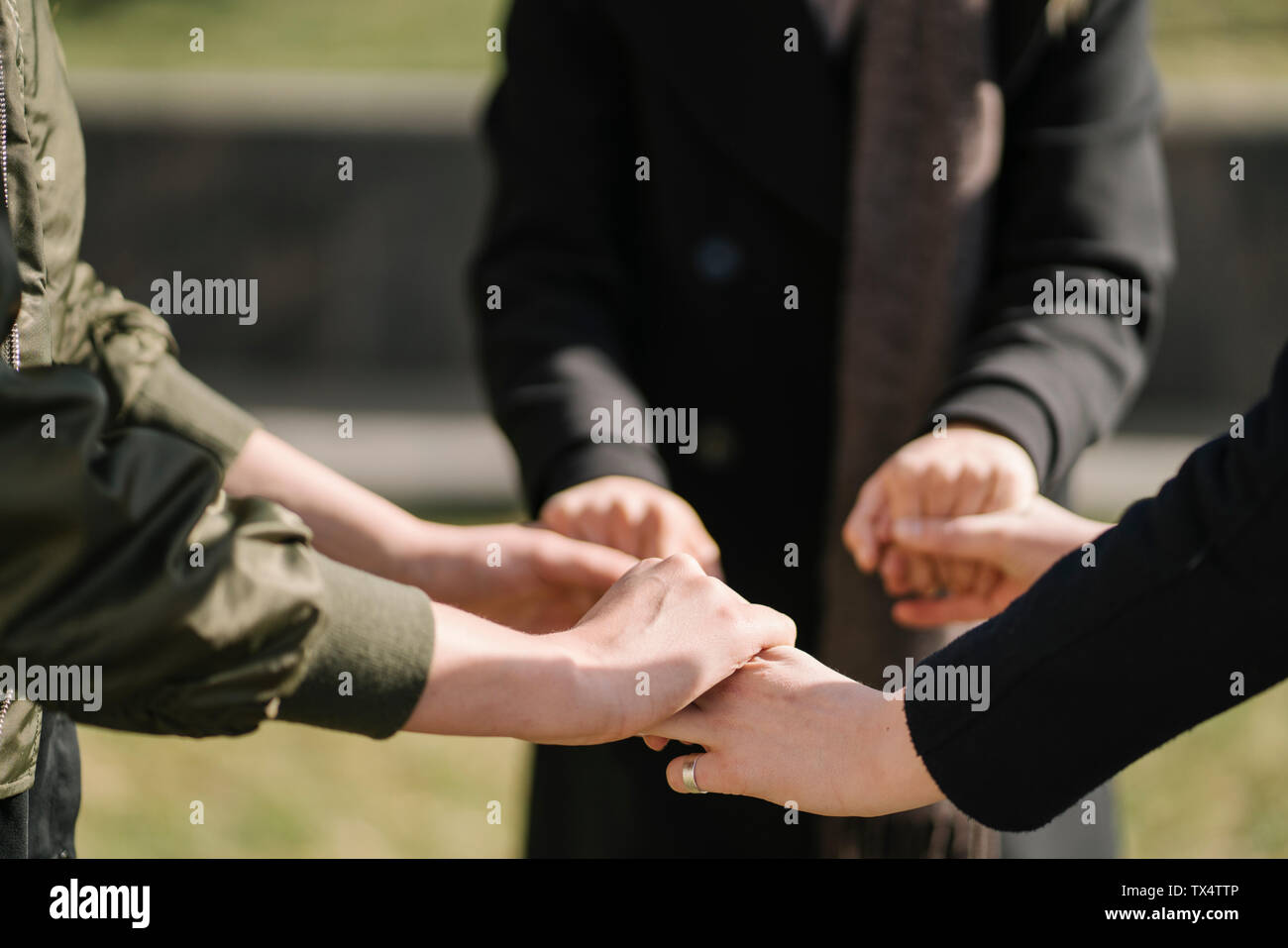 Three people holding hands hi-res stock photography and images - Alamy