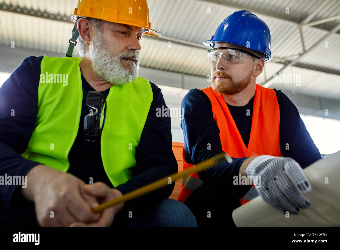 Two men working on plan in factory Stock Photo - Alamy