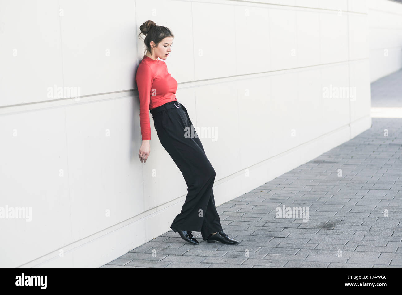 Woman leaning against a wall hi-res stock photography and images - Alamy