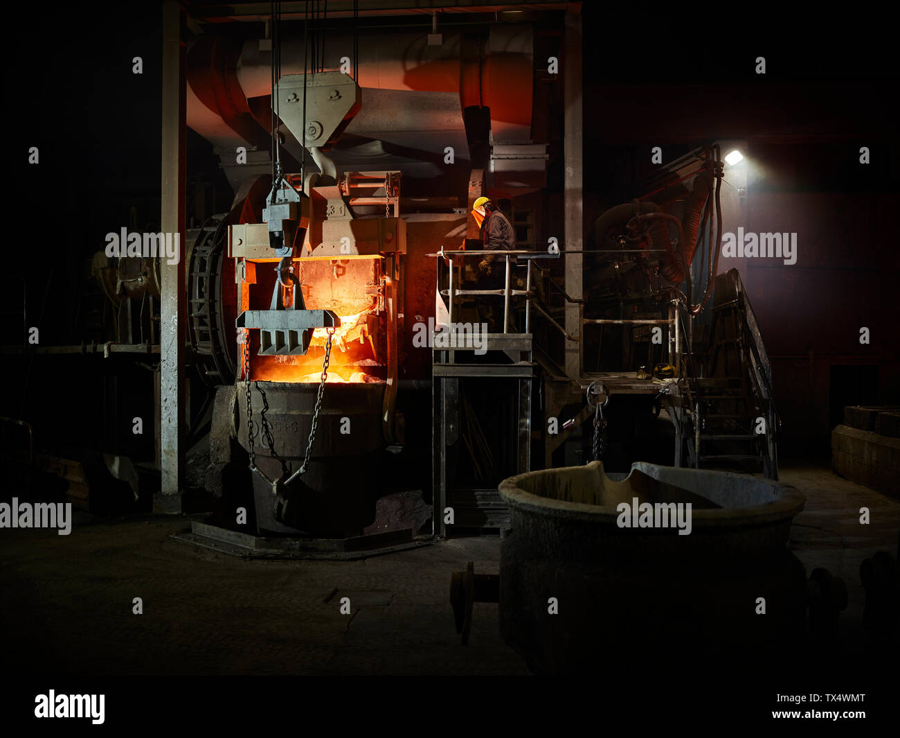 Industry, Worker controlling smelting process Stock Photo - Alamy