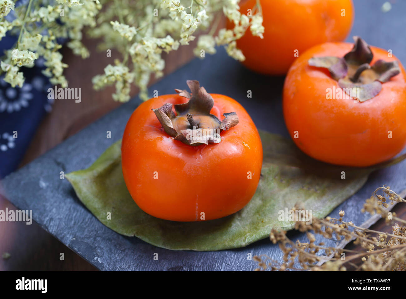 persimmons on stone board Stock Photo - Alamy