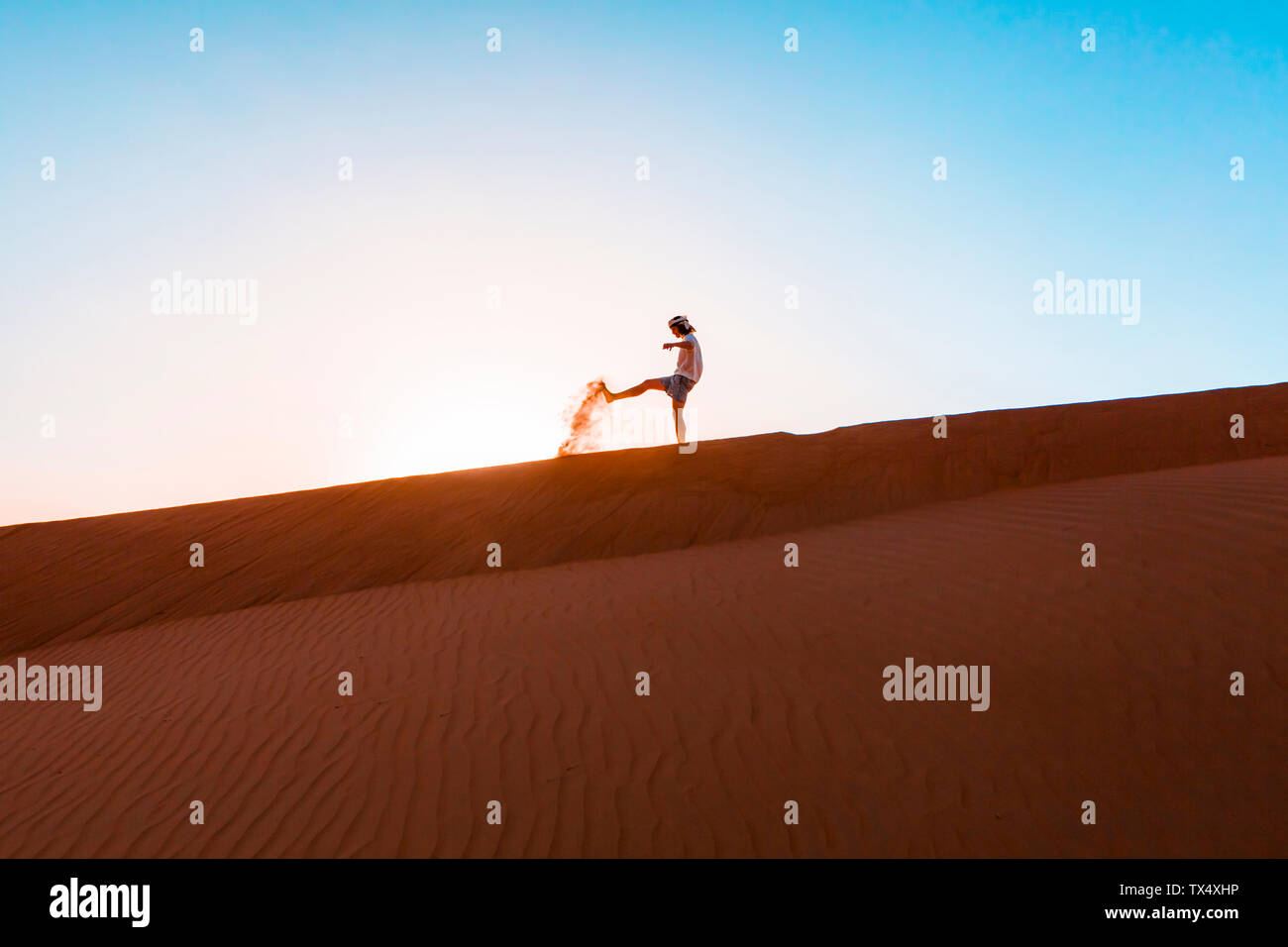 Sultanate Of Oman, Wahiba Sands, Mid adult man is playing with sand in ...