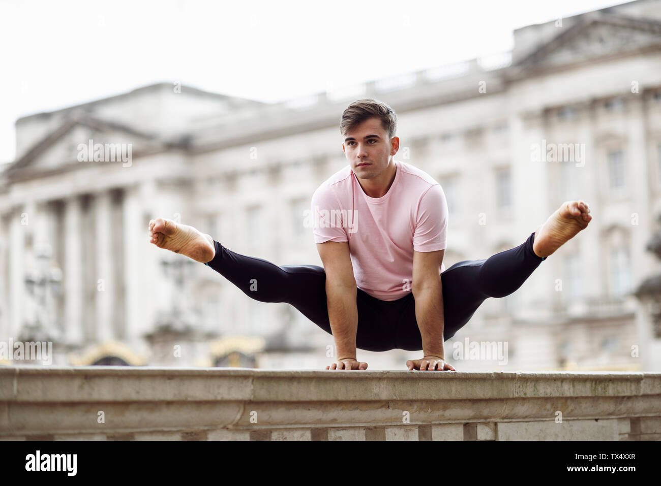 UK, London, young man doing gymnastic acrobatics in front of Buckingham ...