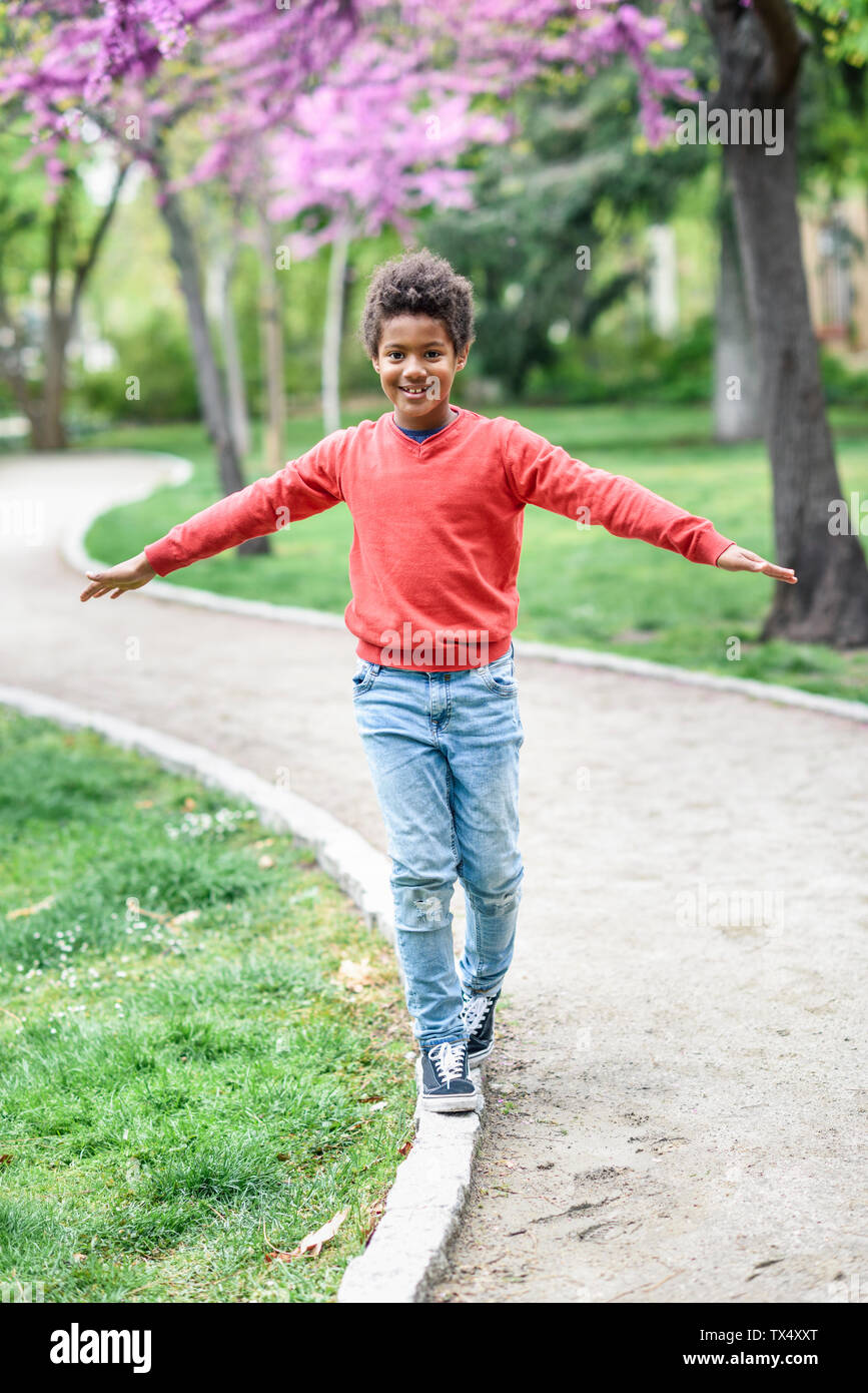 Happy boy balancing in a park Stock Photo - Alamy