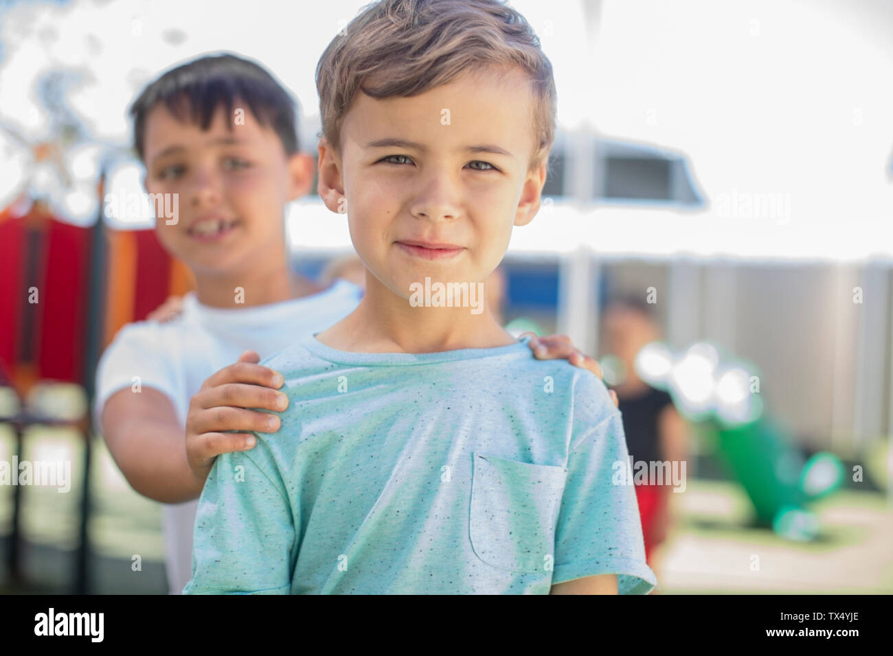 Portrait of smiling boy with friends on playground in kindergarten ...