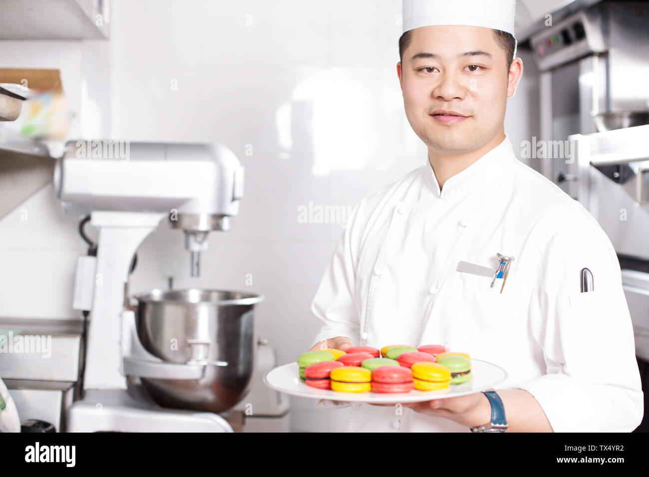 young chinese man chelf making food in modern kitchen Stock Photo - Alamy