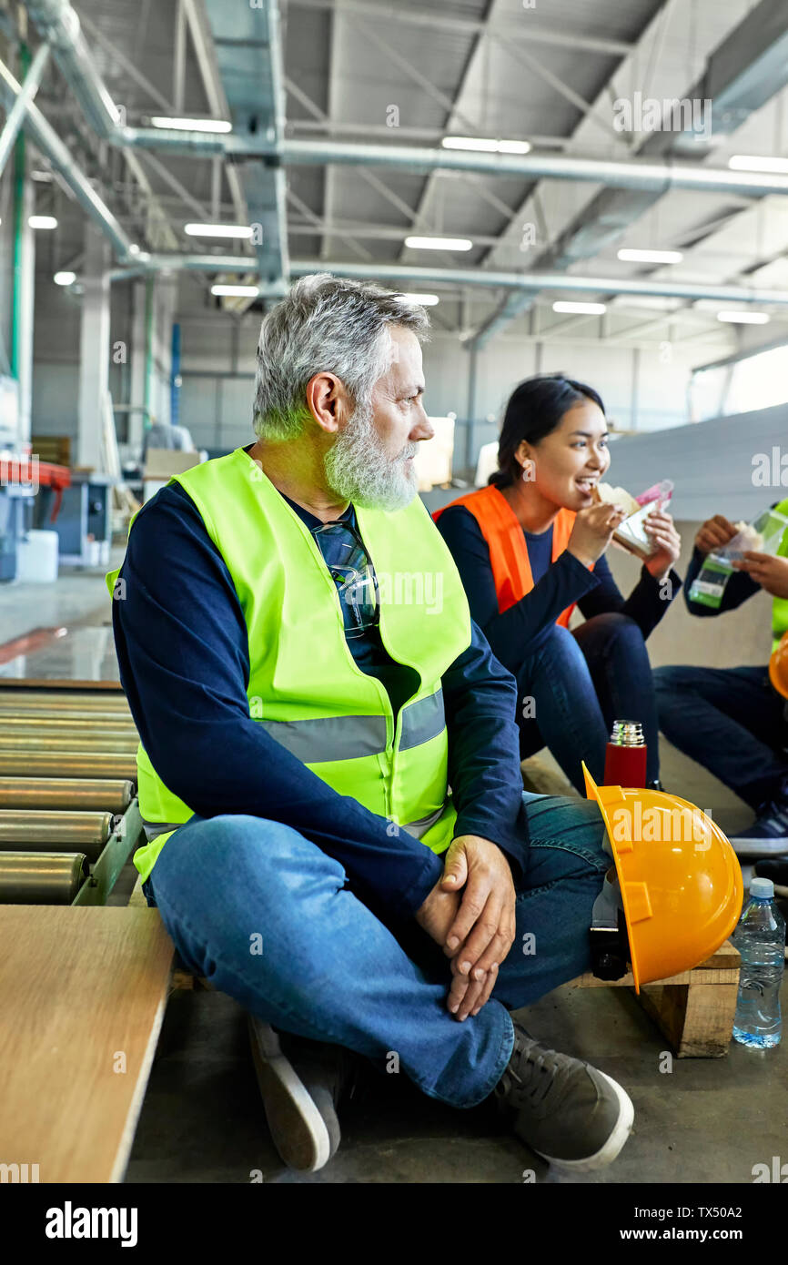 Workers in factory having lunch break together Stock Photo - Alamy