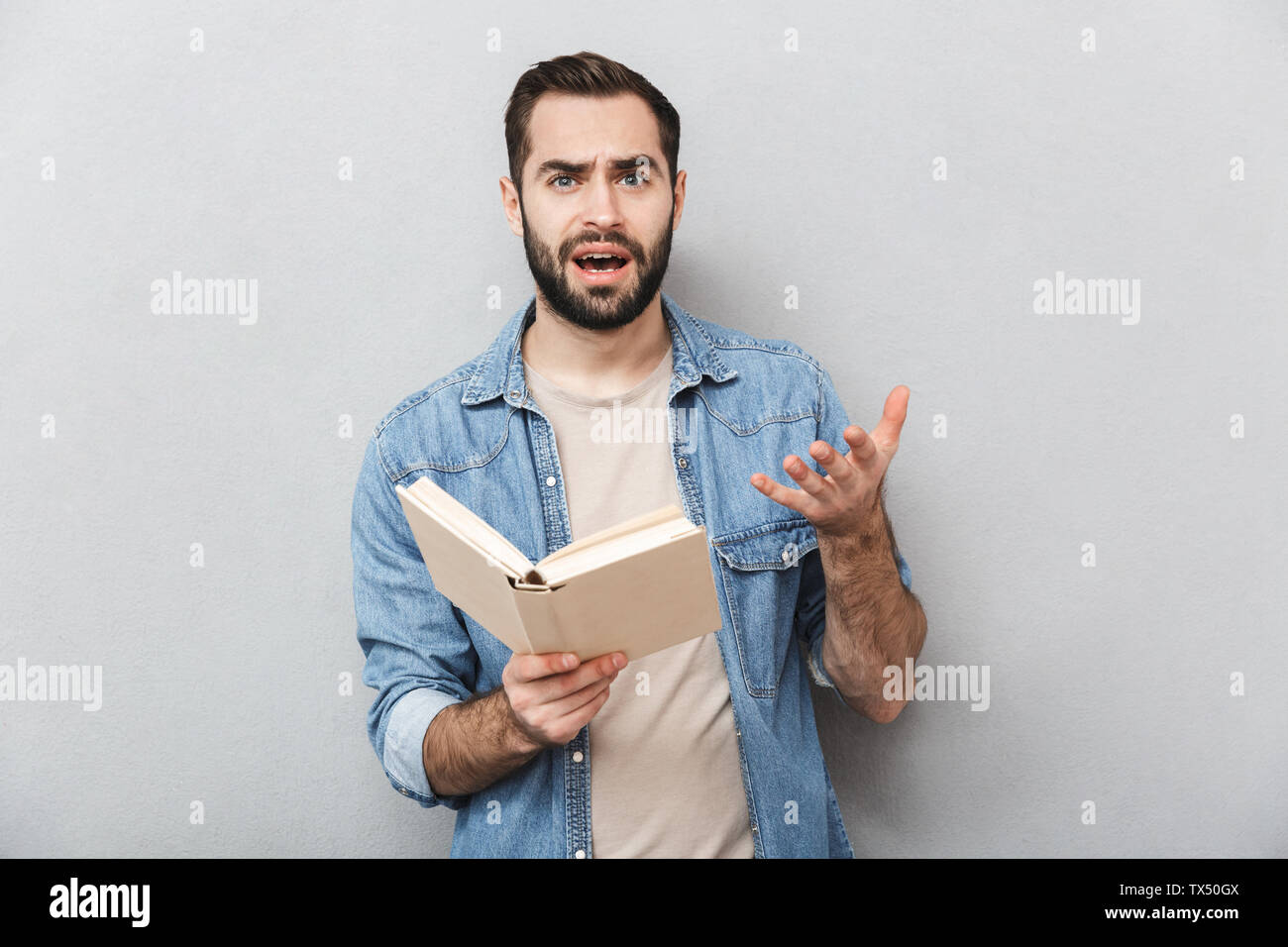 Confused man wearing shirt isolated over gray background, holding open ...