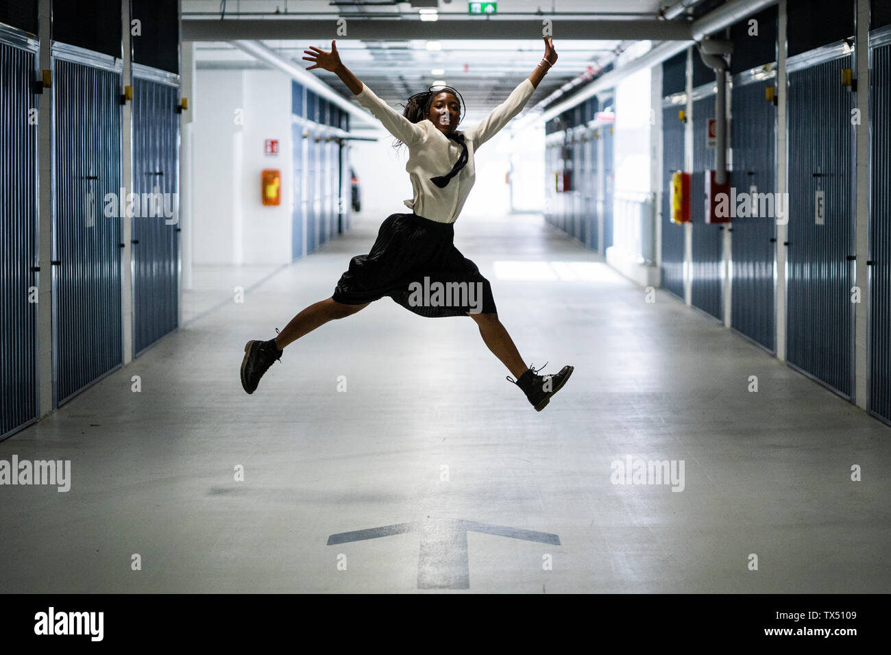 Woman jumping in car park Stock Photo - Alamy