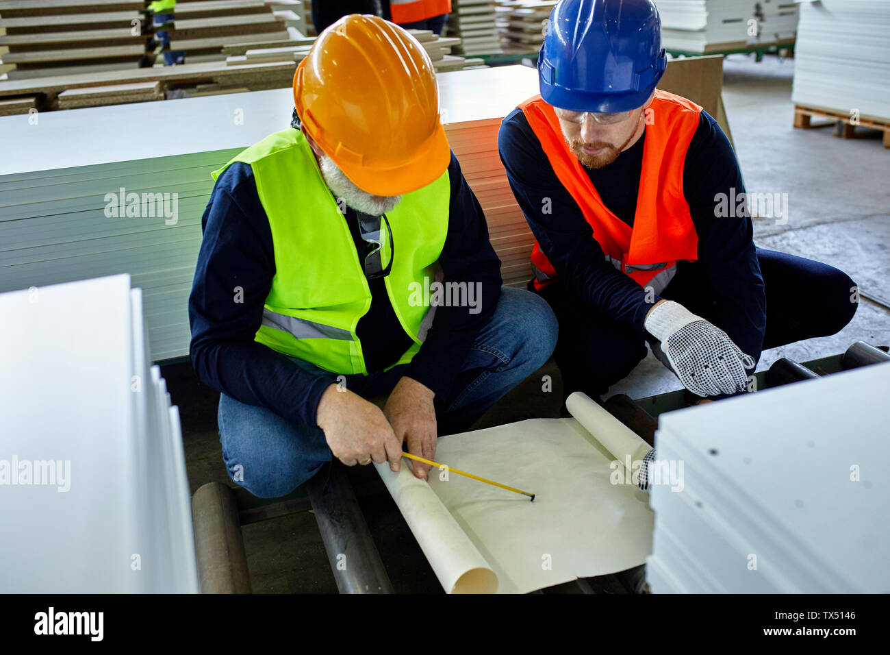 Two men working on plan in factory Stock Photo - Alamy
