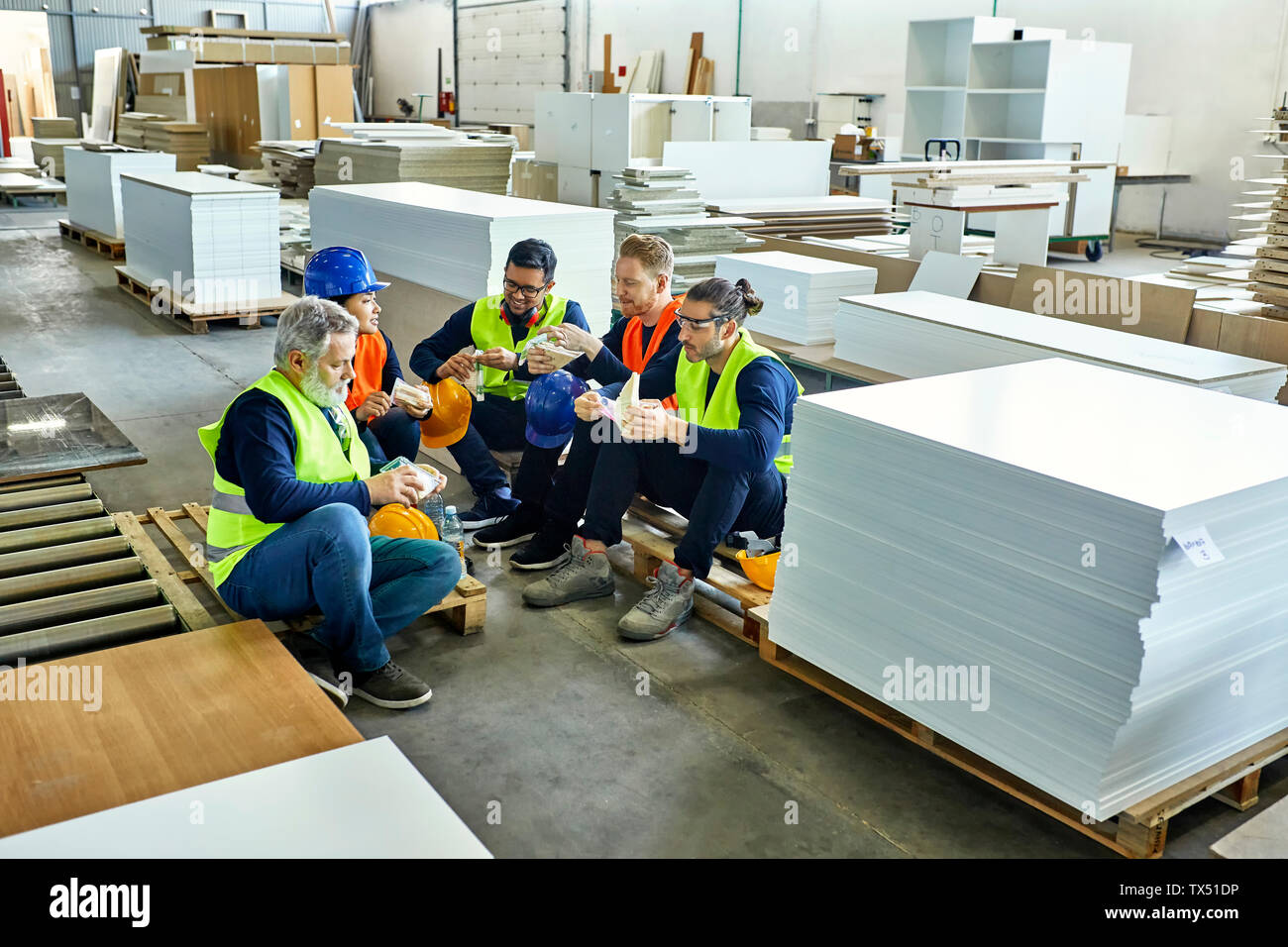 Workers in factory having lunch break together Stock Photo - Alamy