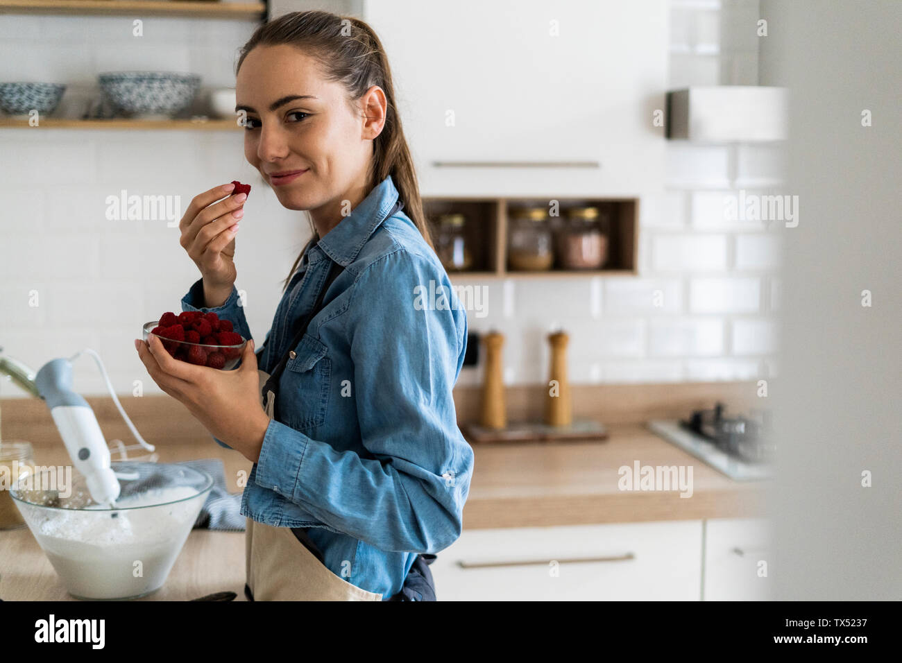 Young woman with bowl of raspberries Stock Photo - Alamy