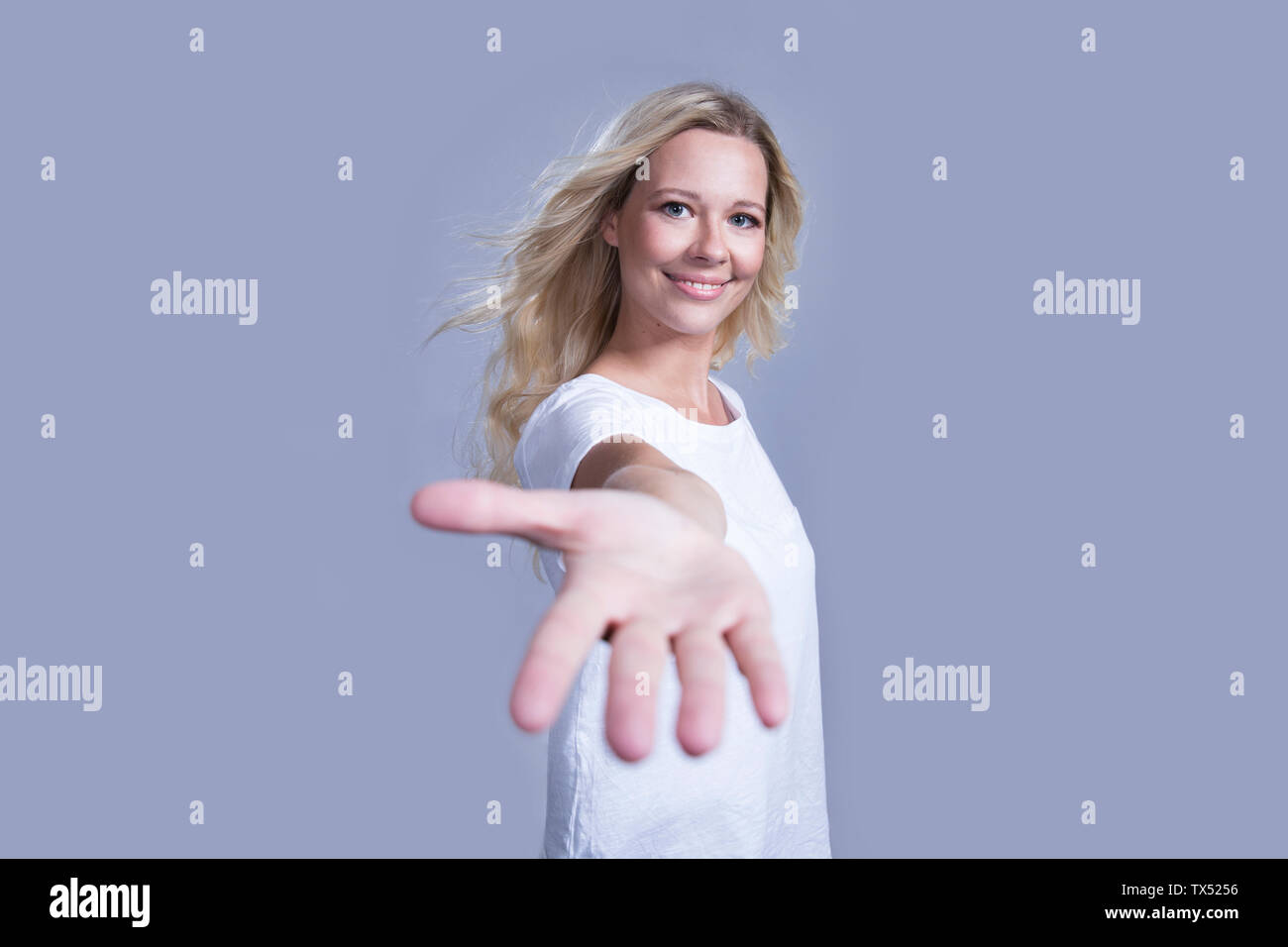 Portrait of smiling blond woman offering helping hand Stock Photo - Alamy