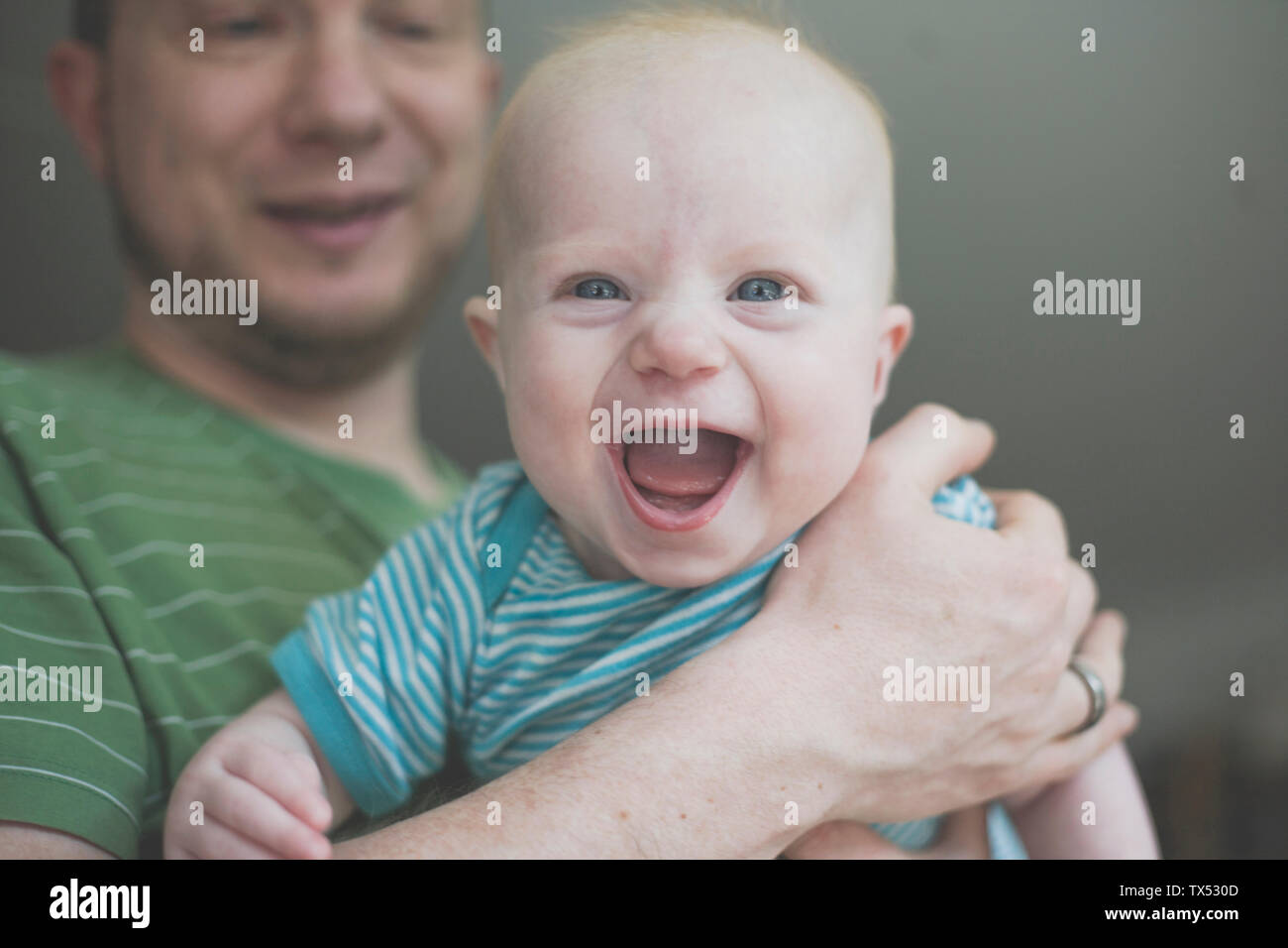 Father holding his laughing baby daughter Stock Photo - Alamy