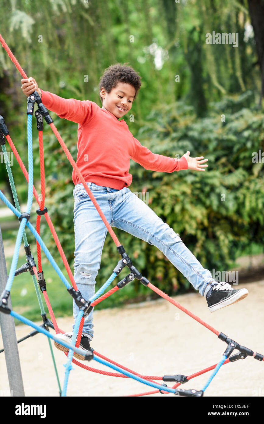 Little boy playing on playground in a park, climbing in a jungle gym Stock Photo - Alamy