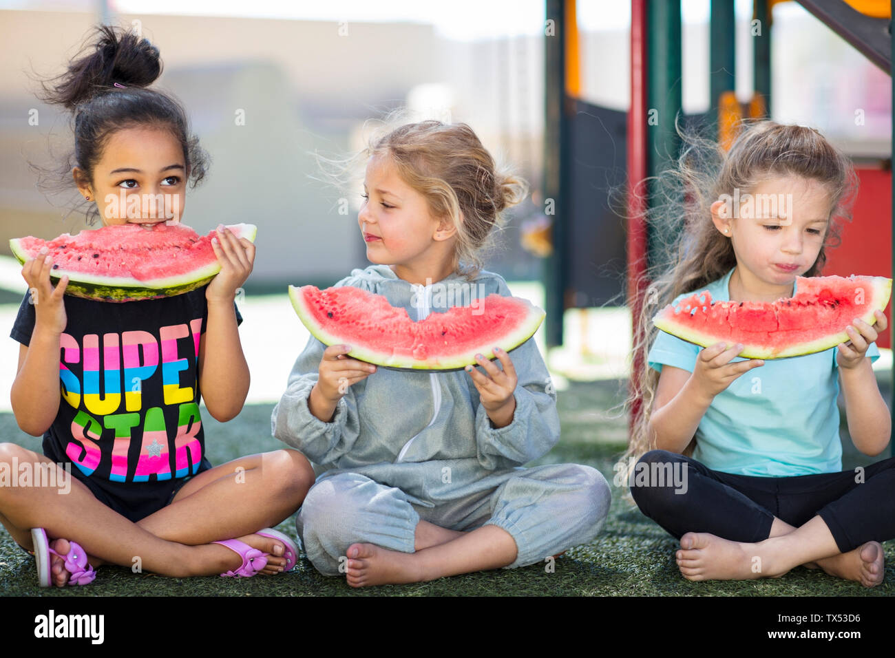 Three girls eating watermelons in kindergarten Stock Photo - Alamy