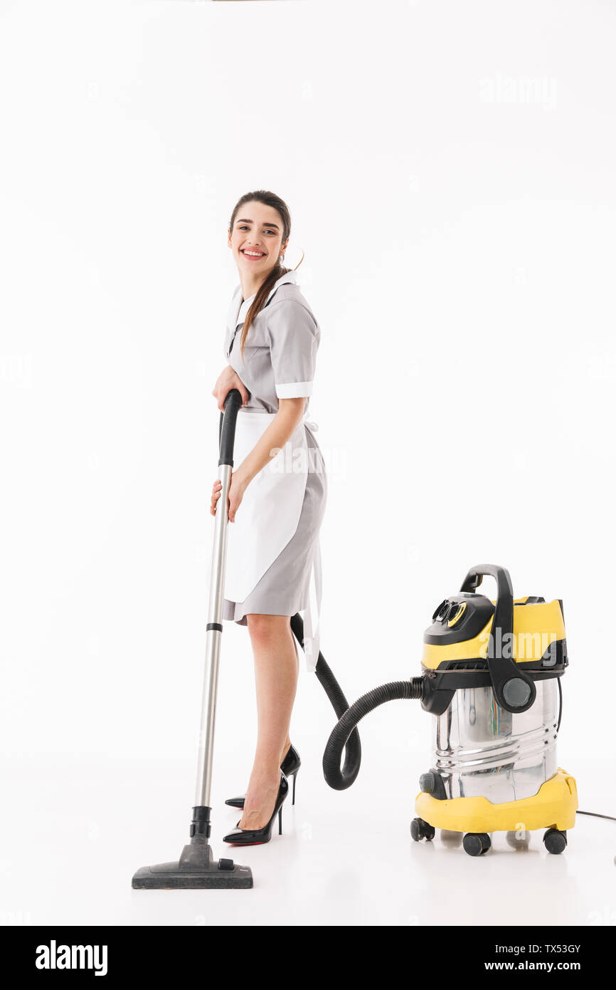 Full length photo of attractive maid 20s dressed in uniform cleaning ...