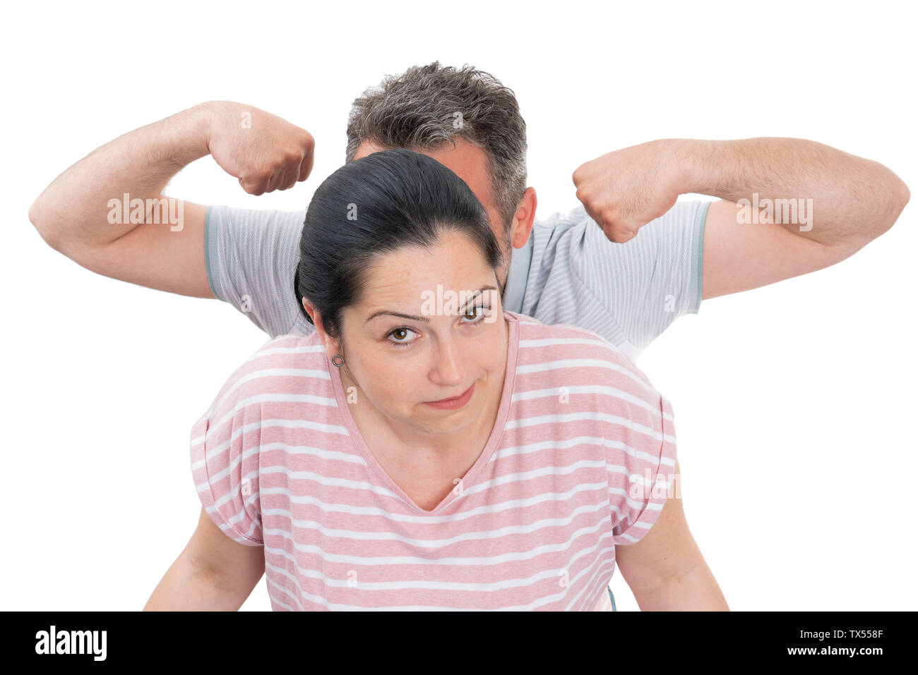Man showing muscles on arms as hiding behind woman with confused ...