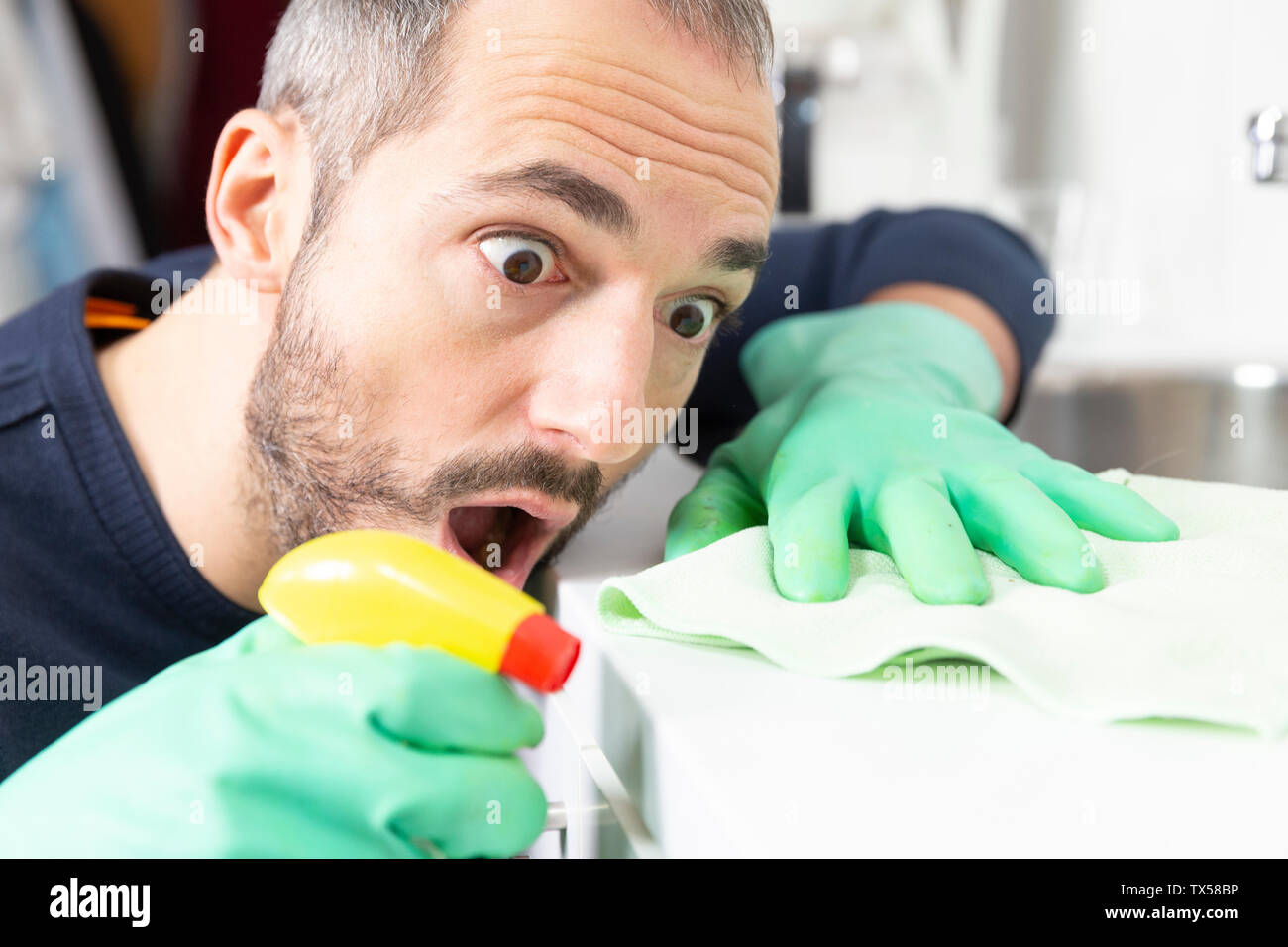 A man using cleaning products to clean Stock Photo - Alamy