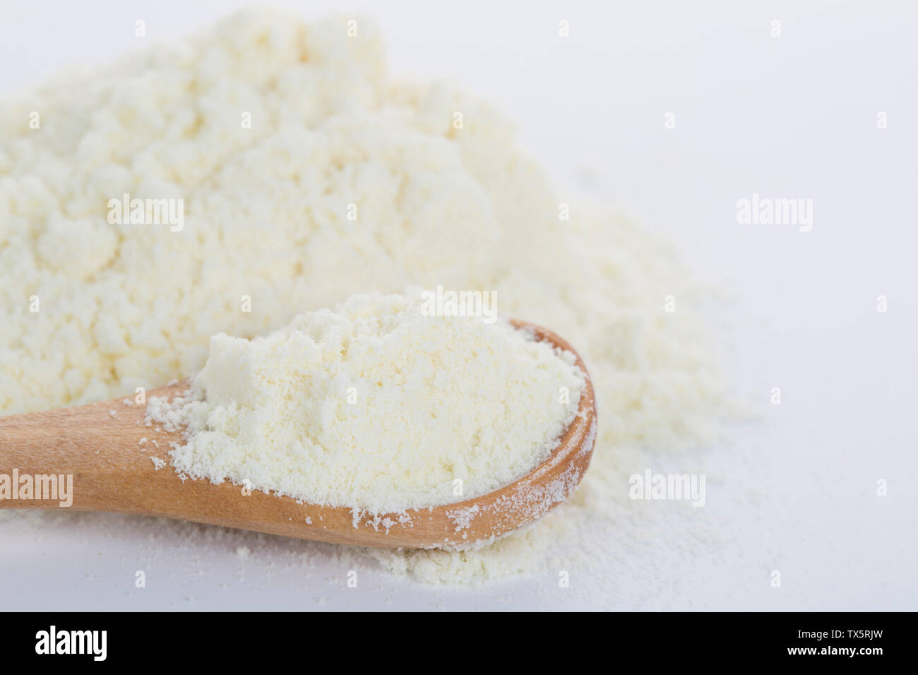 A wooden spoon and milk powder on a white background Stock Photo - Alamy