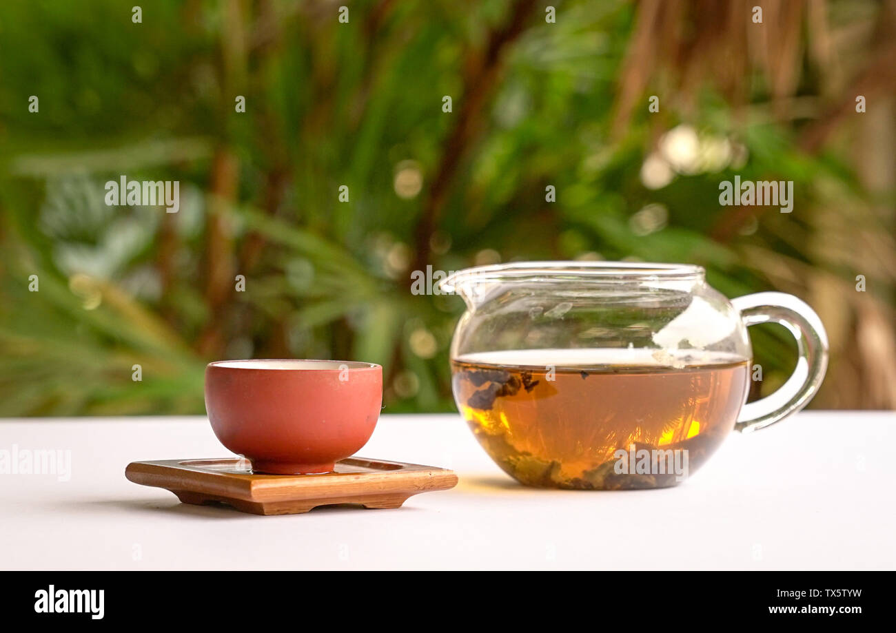 Cup of chinese tea in a lovely traditional tea cup with teapot by the ...