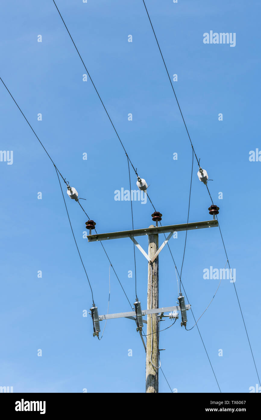 Rural electrical power lines in Cornwall, UK set against blue sky ...
