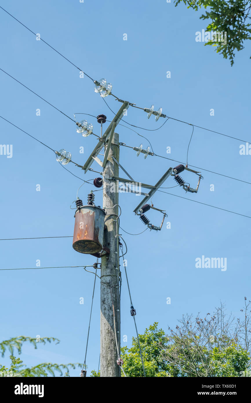 Rural electrical power lines in Cornwall, UK set against blue sky ...