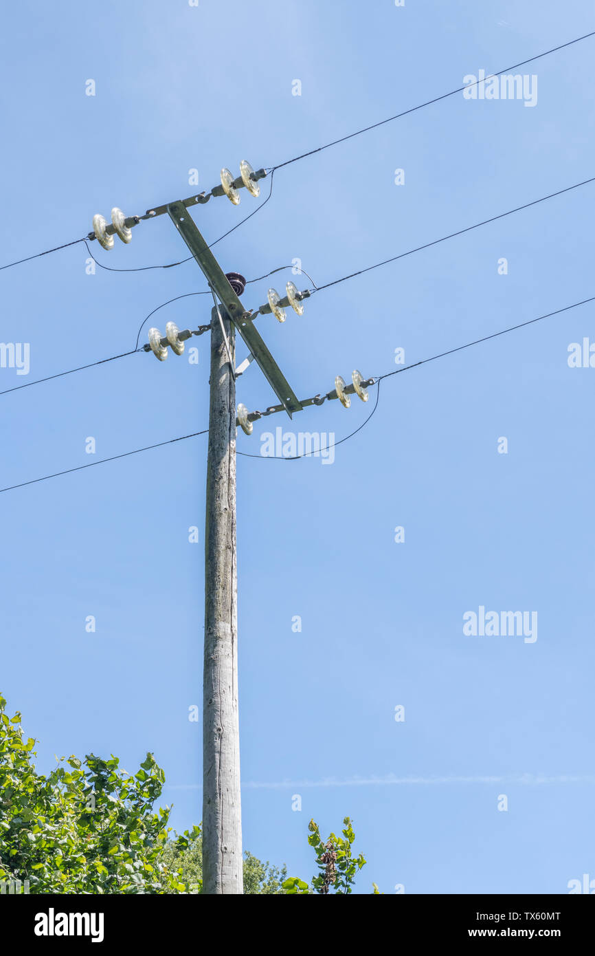 Rural electrical power lines in Cornwall, UK set against blue sky ...