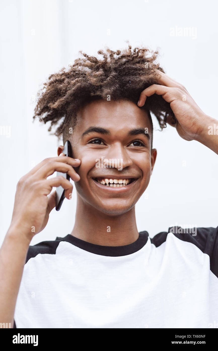 Happy african man student standing outdoors, using mobile phone Stock ...