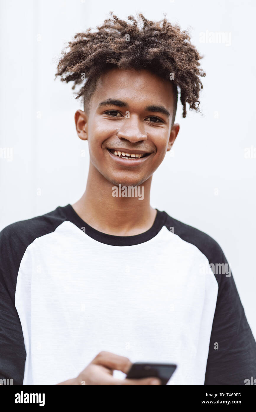 Happy african man student standing outdoors, using mobile phone Stock ...