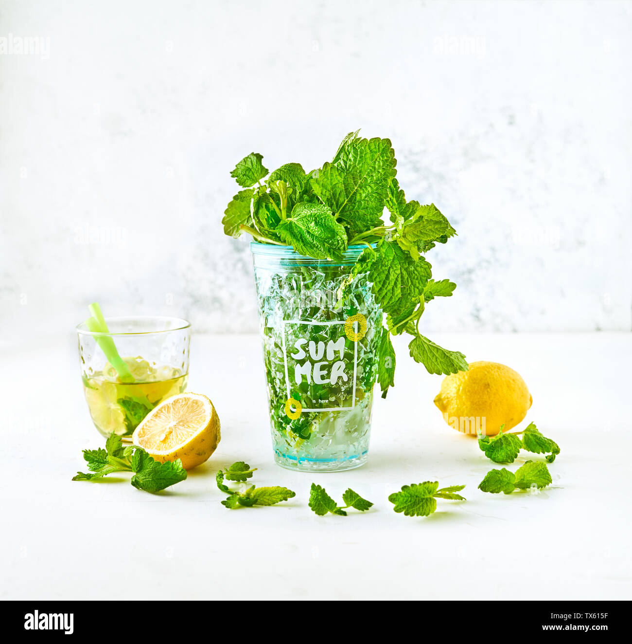 Mint leaves, lemons, and lemonade on white background Stock Photo - Alamy