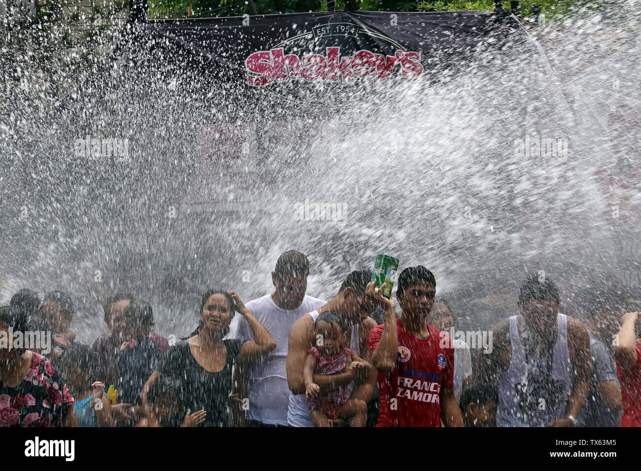 San Juan, Philippines. 24th June, 2019. Residents are sprayed wet ...