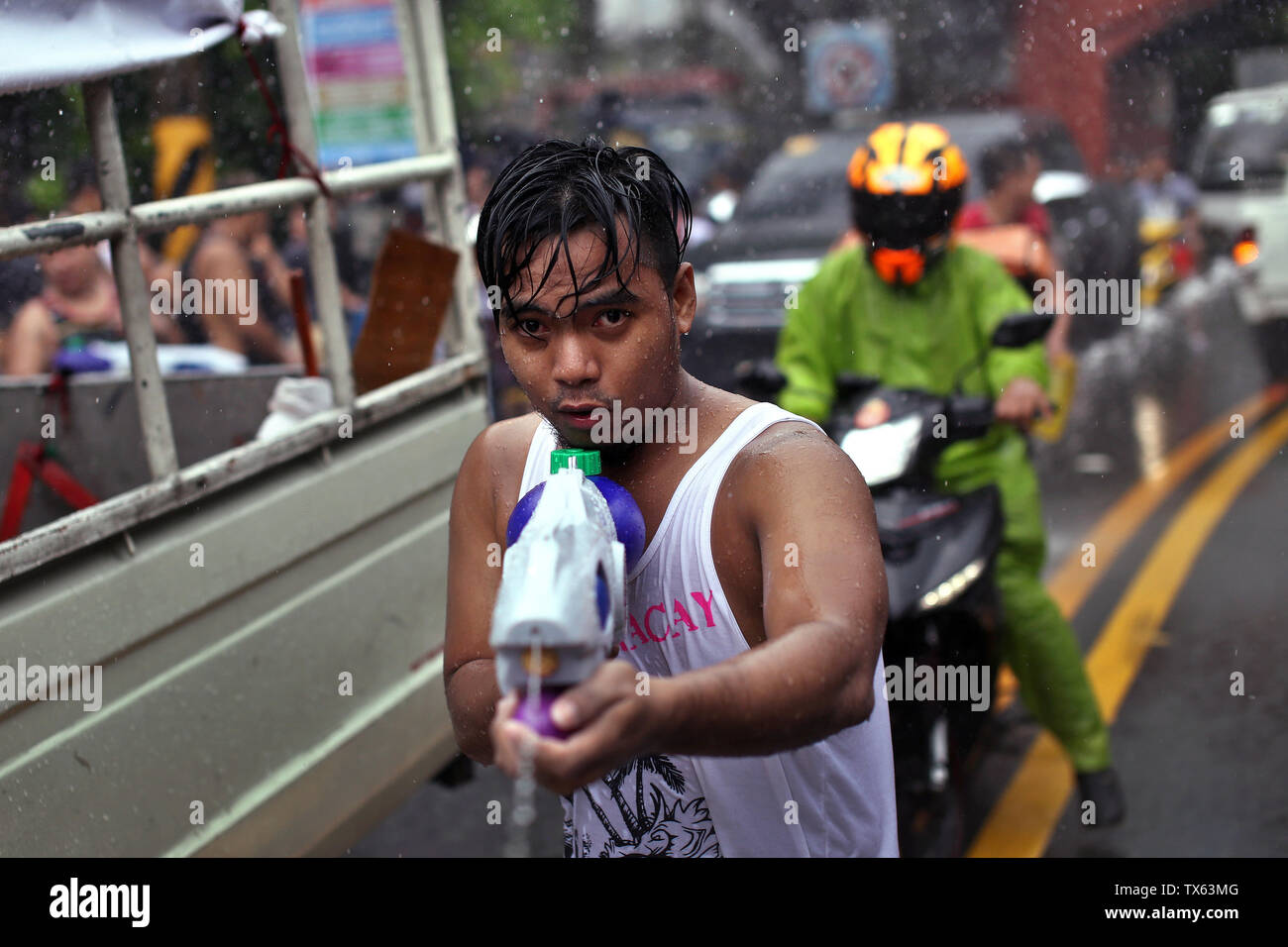 San Juan, Philippines. 24th June, 2019. A man sprays other residents ...