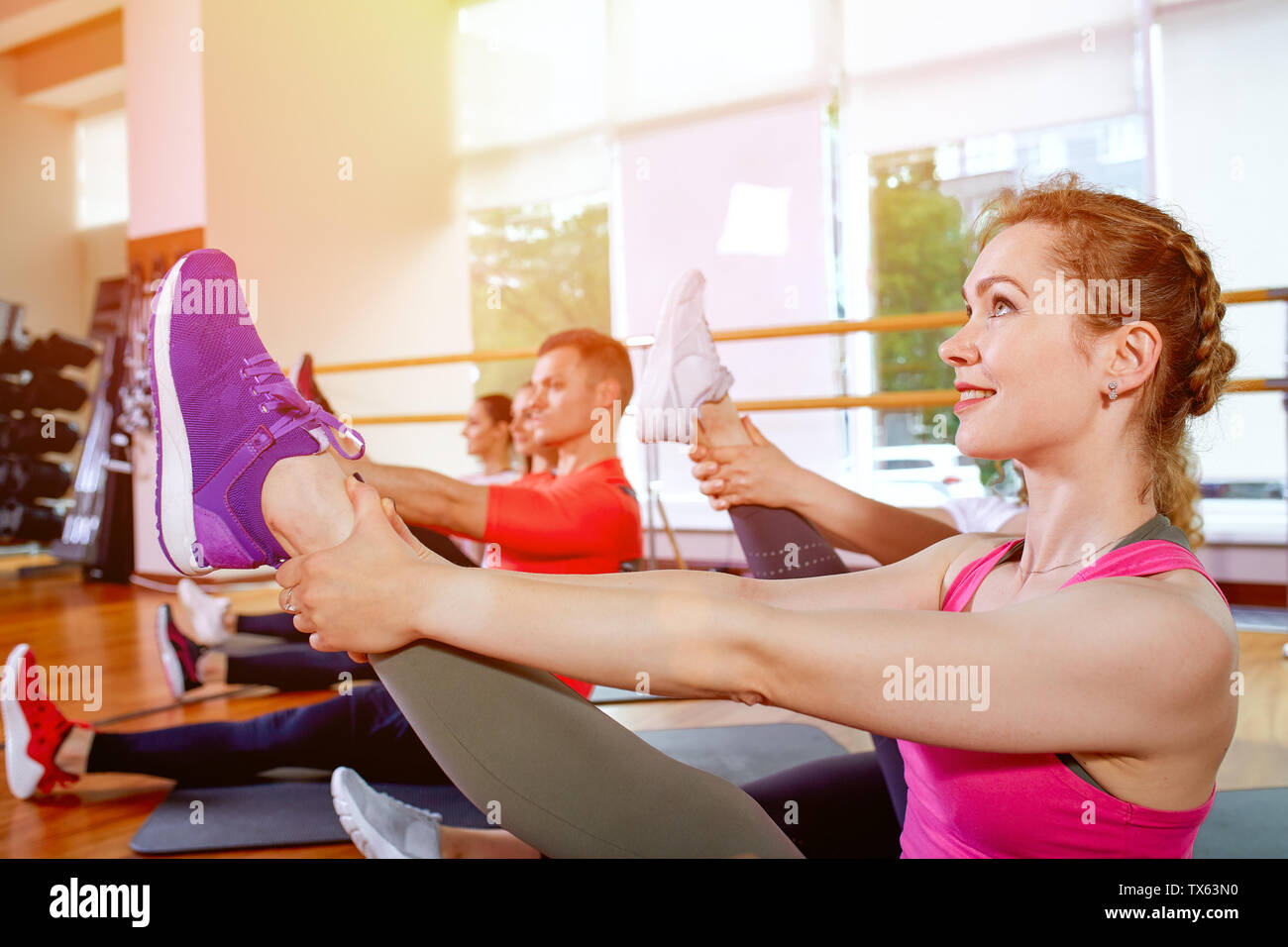 Fitness group does exercises for stretching muscles in a fitness lesson ...