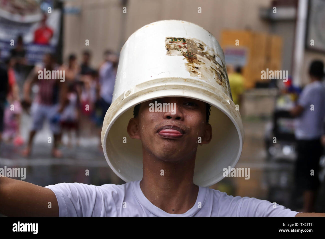 San Juan, Philippines. 24th June, 2019. A man carries a bucket of water ...