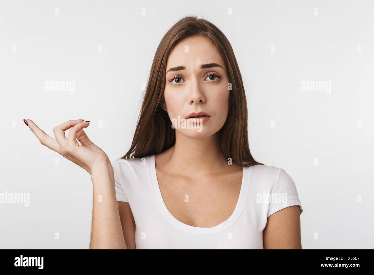 Portrait of a confused beautiful young woman wearing casual clothing ...