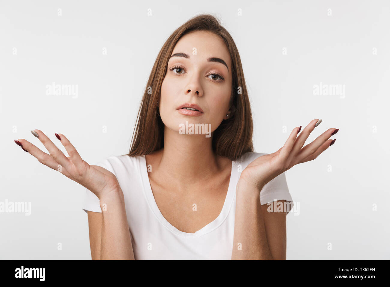 Portrait of a beautiful confused young woman wearing casual clothing ...