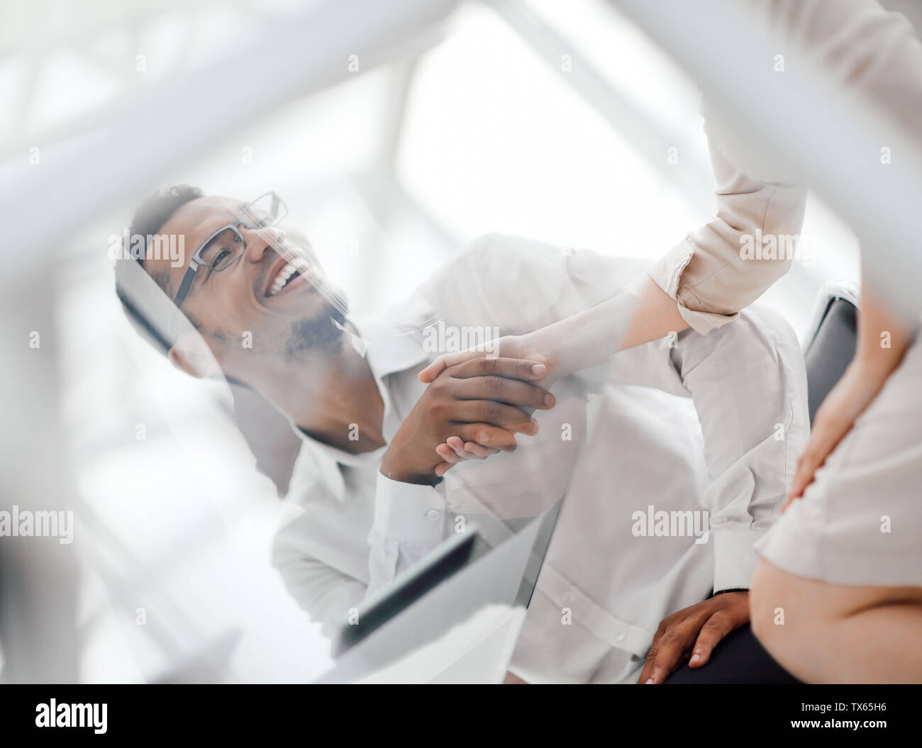 bottom view.handshake employees at the Desk in the office . photo with ...