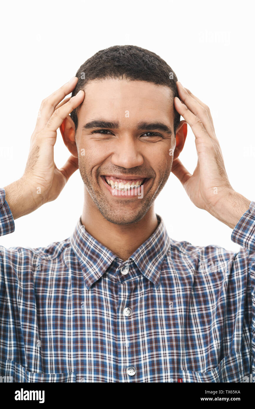 Close up of a happy young man wearing plaid shirt standing isolated ...