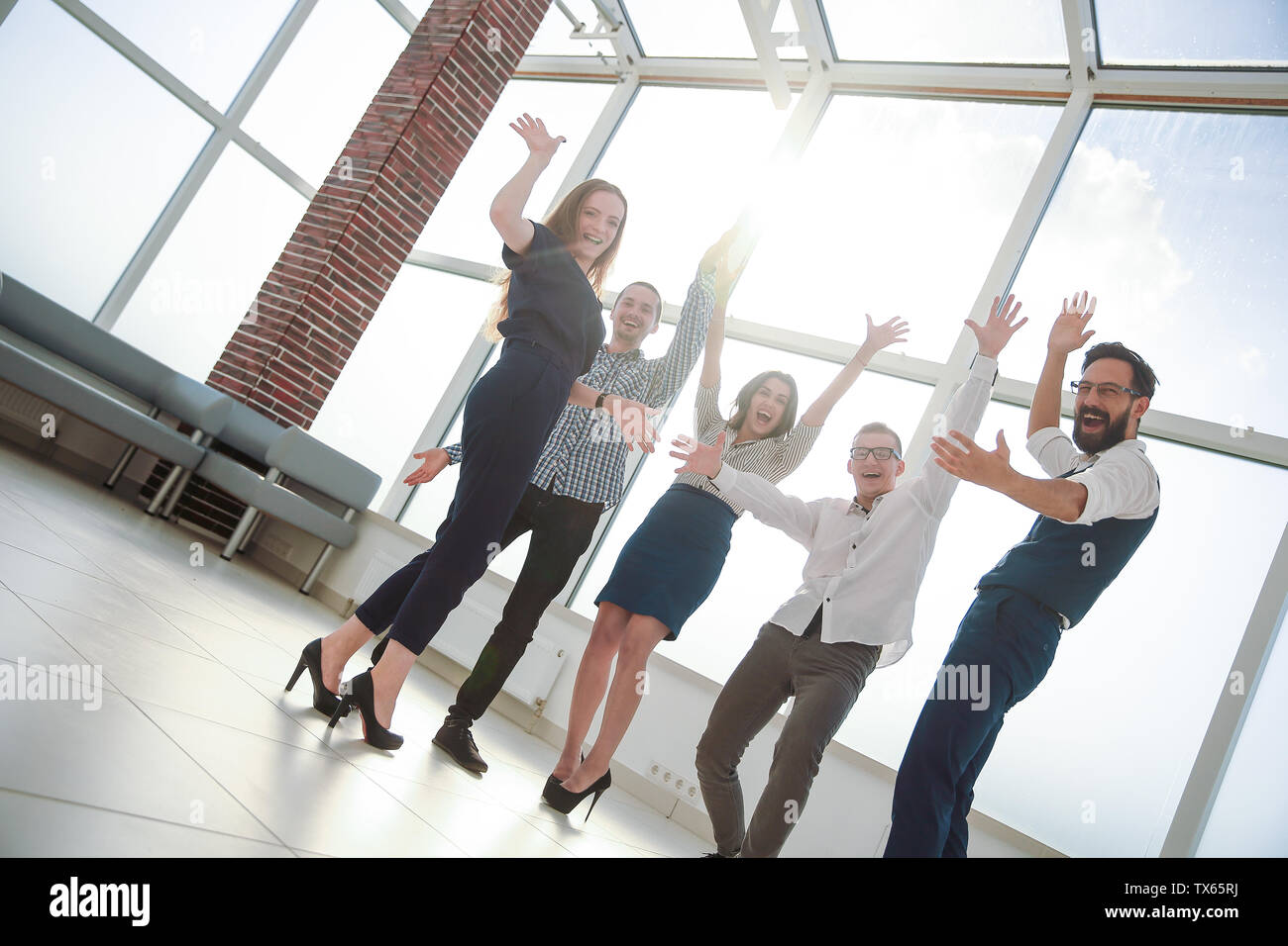 in full growth. cheering business team standing in the office.the ...