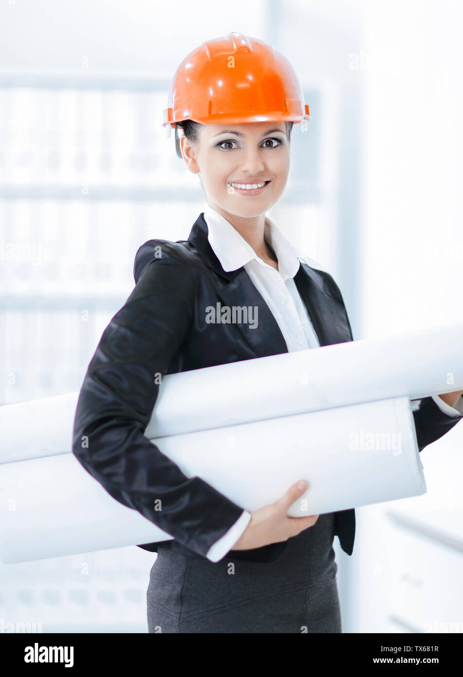confident female engineer with blueprints in the background of the ...
