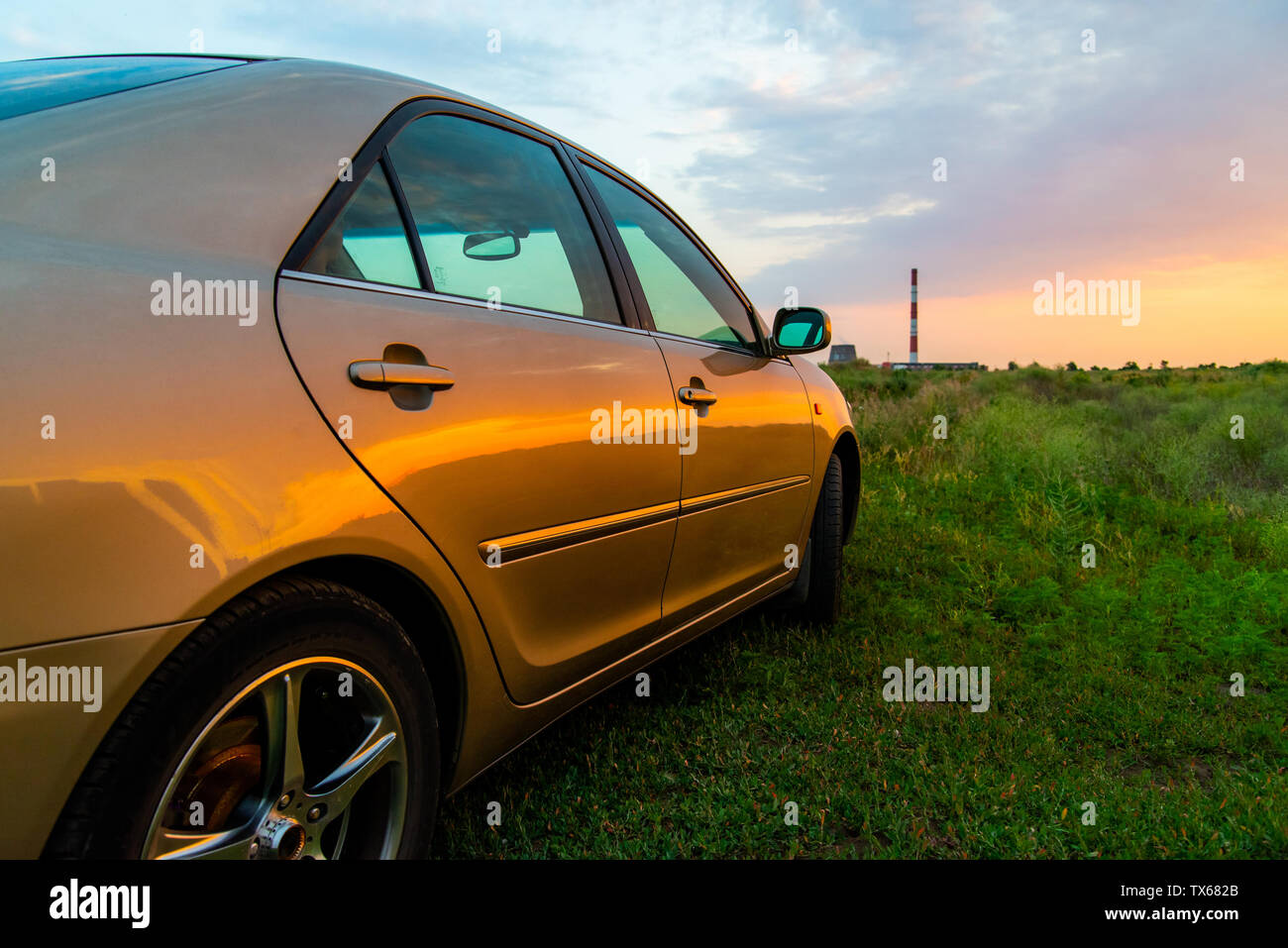 Rear-side view of a luxury car on sunset Stock Photo - Alamy