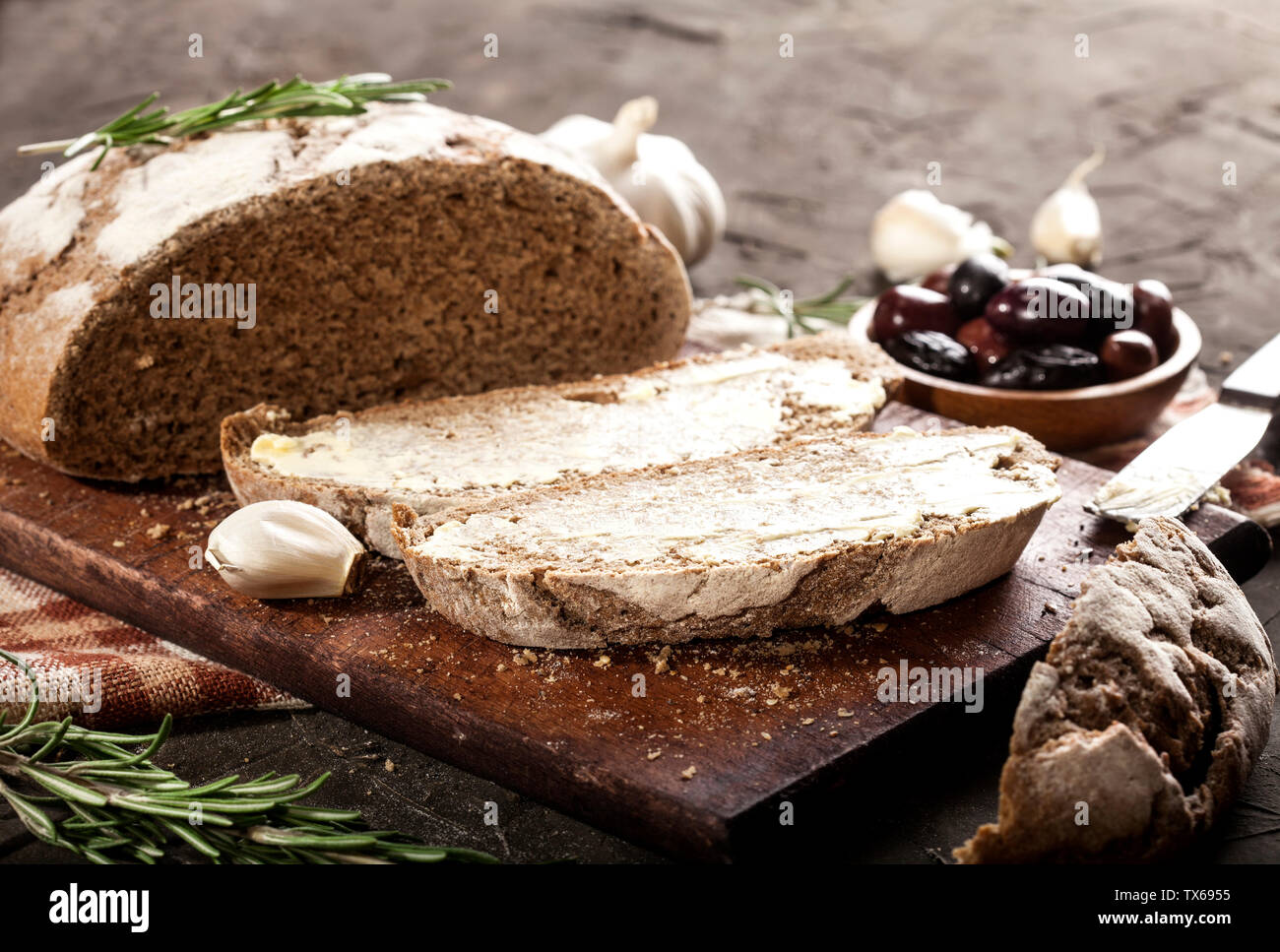 Closeup of sliced traditional toast bread with butter, olives, garlic ...